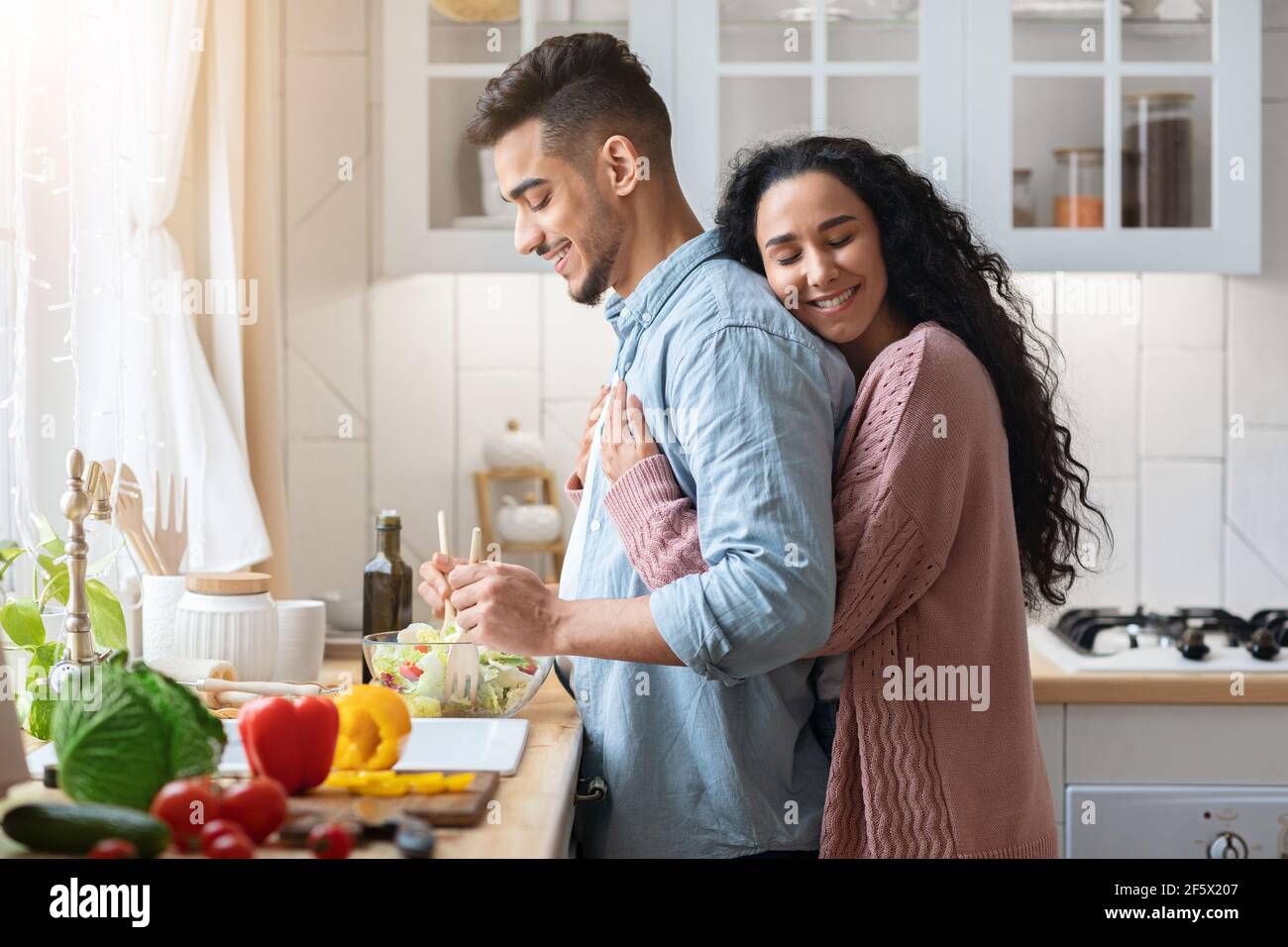 Loving Arab Woman Hugging Husband From Back While He Cooking In Kitchen ...