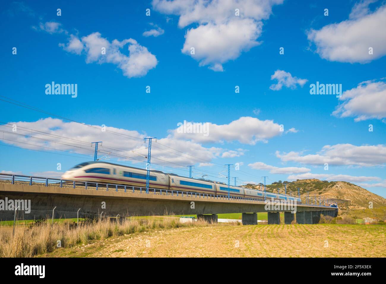 Madrid-Barcelona AVE high-speed train traveling along a viaduct ...
