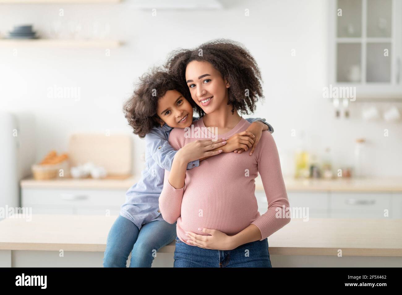 Kid girl hugging pregnant mother hi-res stock photography and images ...