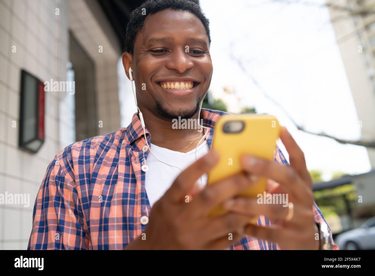 Man using his mobile phone on the street Stock Photo - Alamy