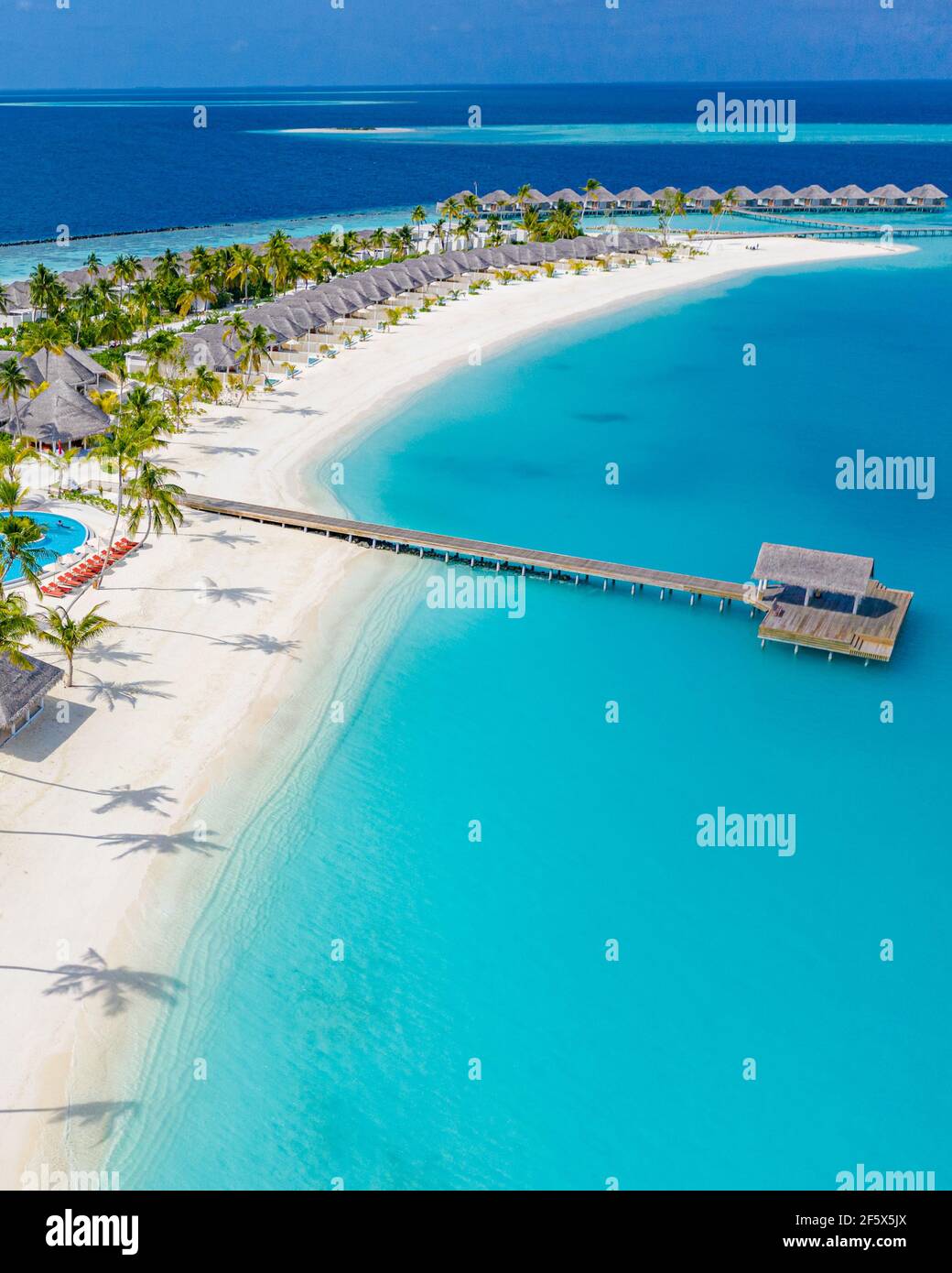 Aerial view of Maldives island, luxury water villas resort and wooden ...