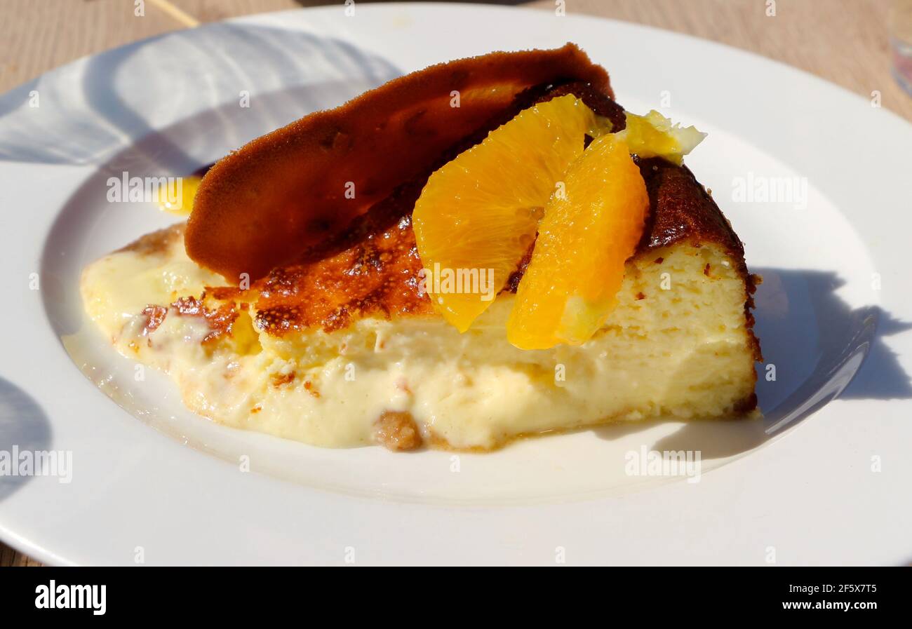 Sponge cake with ice cream and fruit on a white plate in natural ...