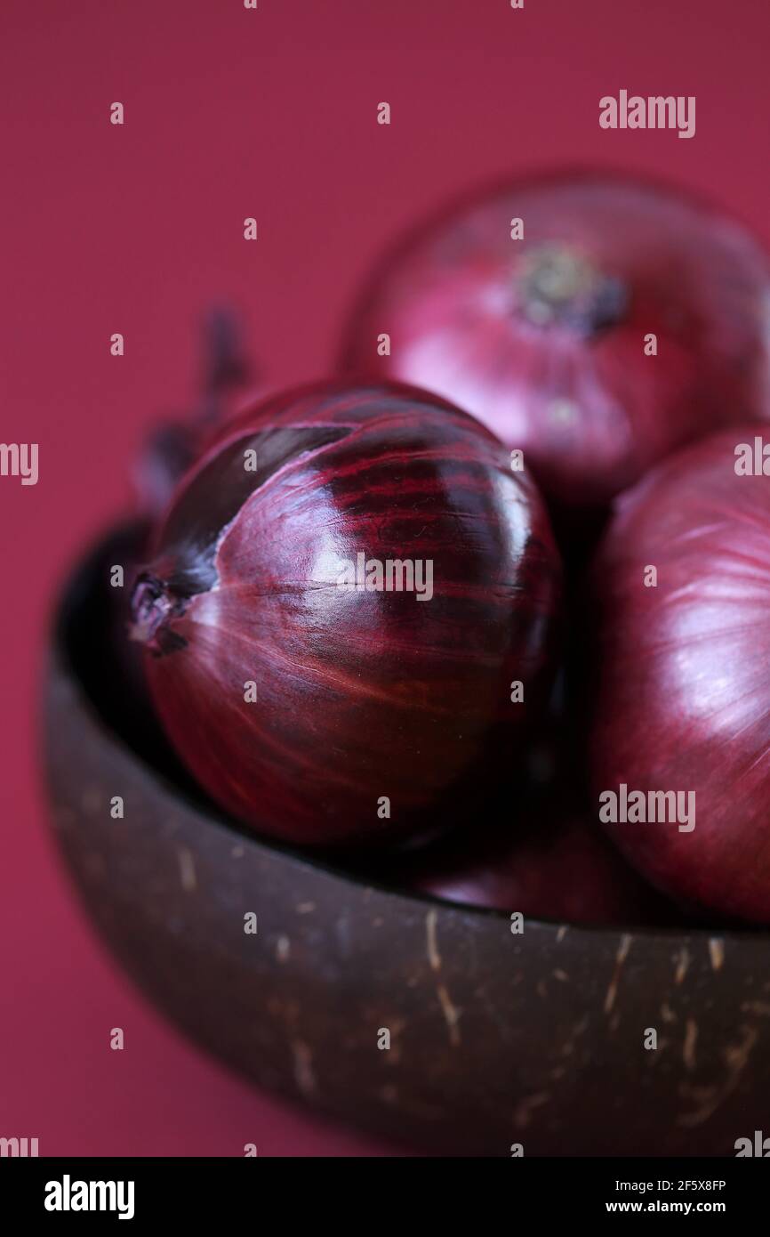 Red onion close-up on a bright burgundy background.Fresh farm organic ...