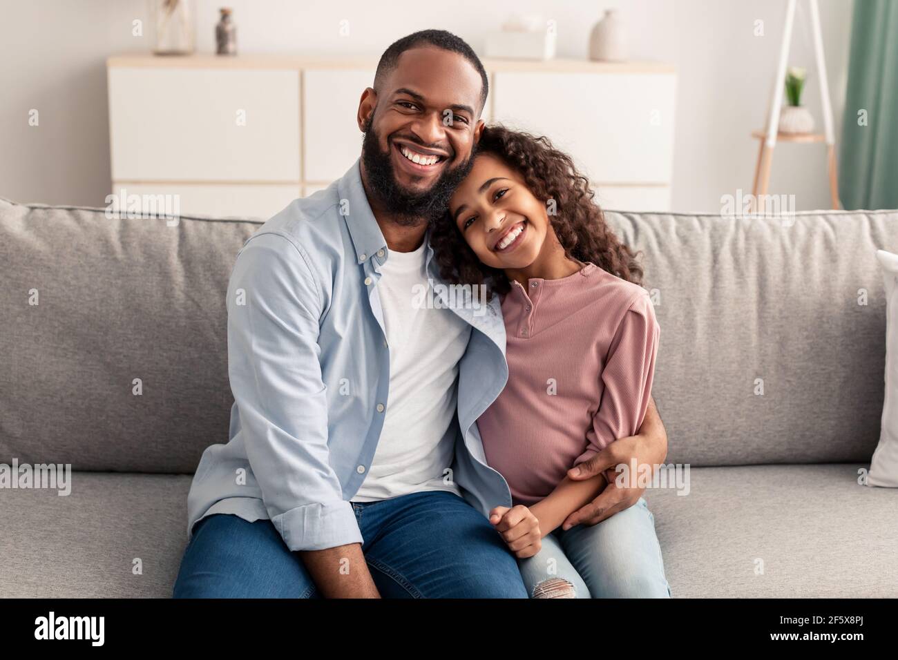 Portrait of black father and daughter hugging Stock Photo - Alamy