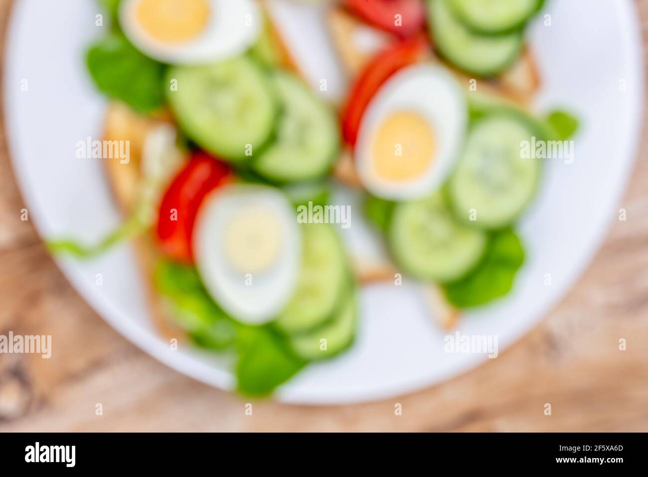 Fried white bread toasts with vegetable and egg slices on a plate ...