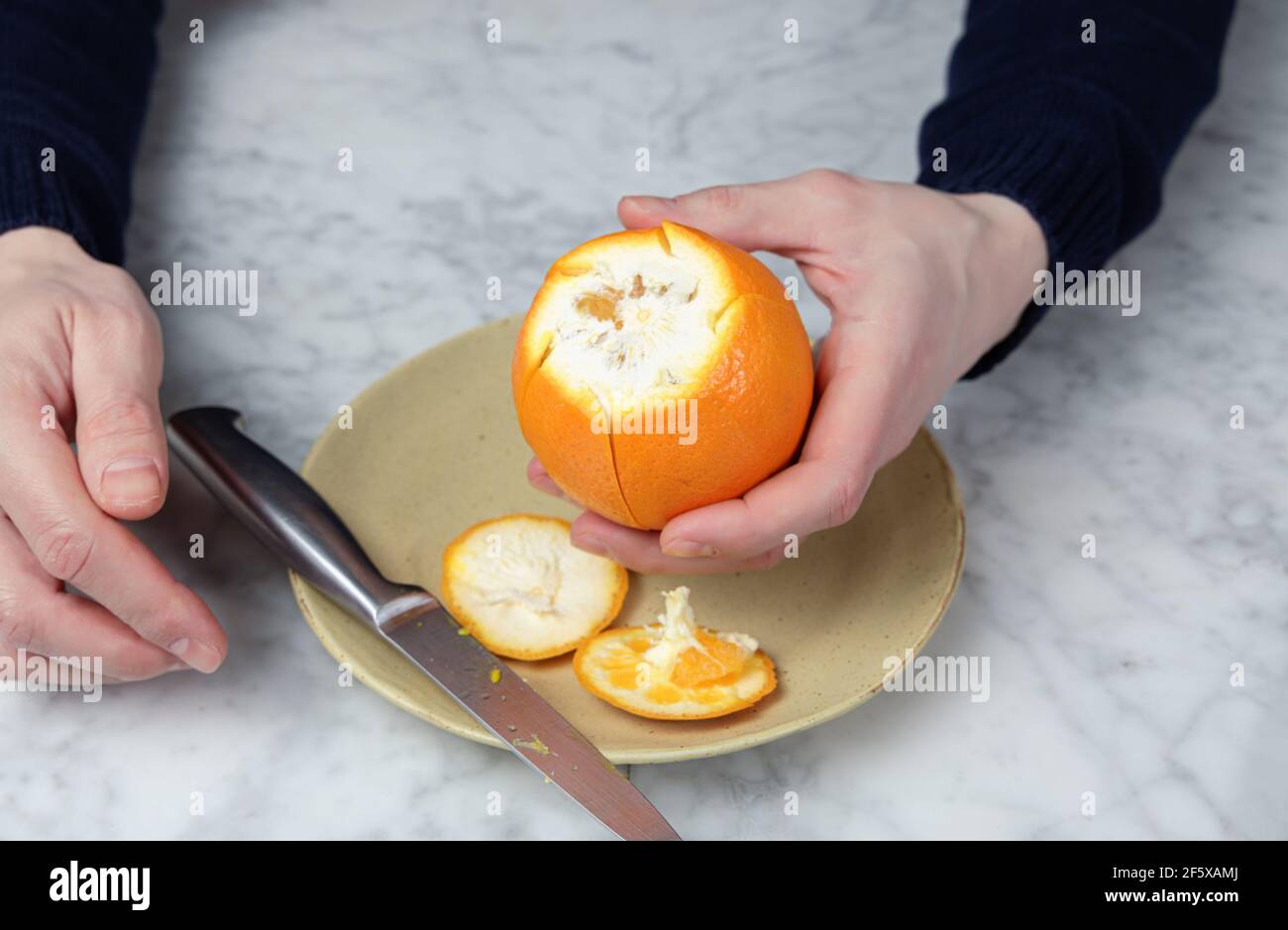 Man's hands peeling an orange with a knife. Healthy food concept Stock ...