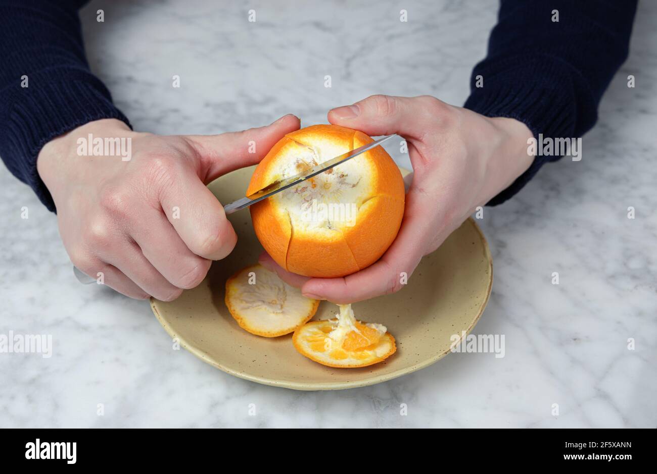 Man's hands peeling an orange with a knife. Healthy food concept Stock ...