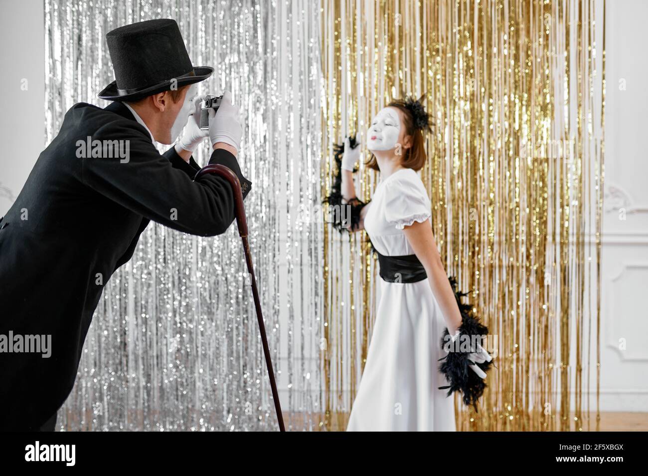 Mime artists, lady poses at gentleman with camera Stock Photo - Alamy