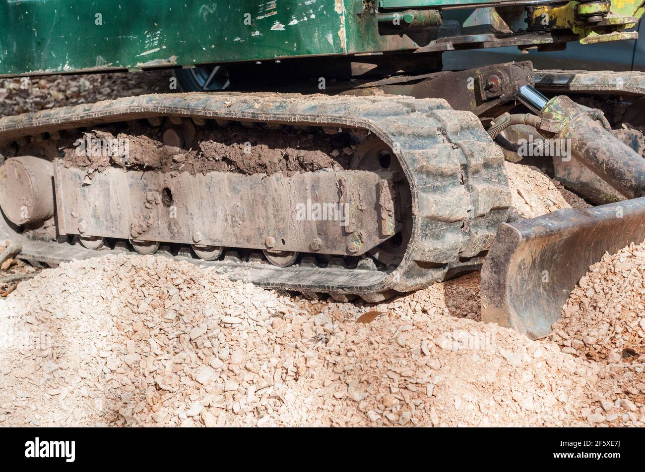 track roller detail, small hydraulic shovel on top a gravel pile Stock ...