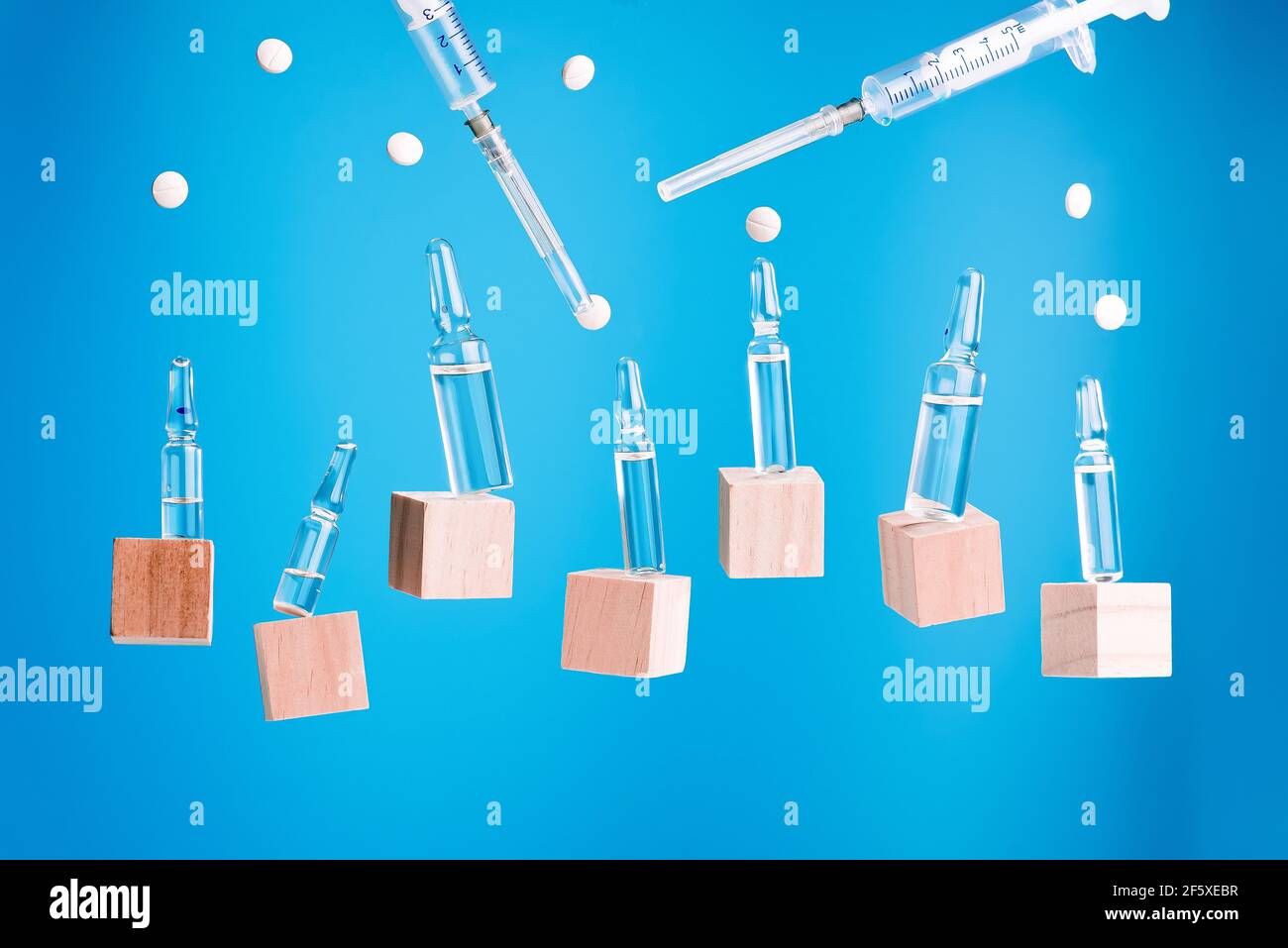Ampoules with medicine on wooden blocks on a blue background with ...