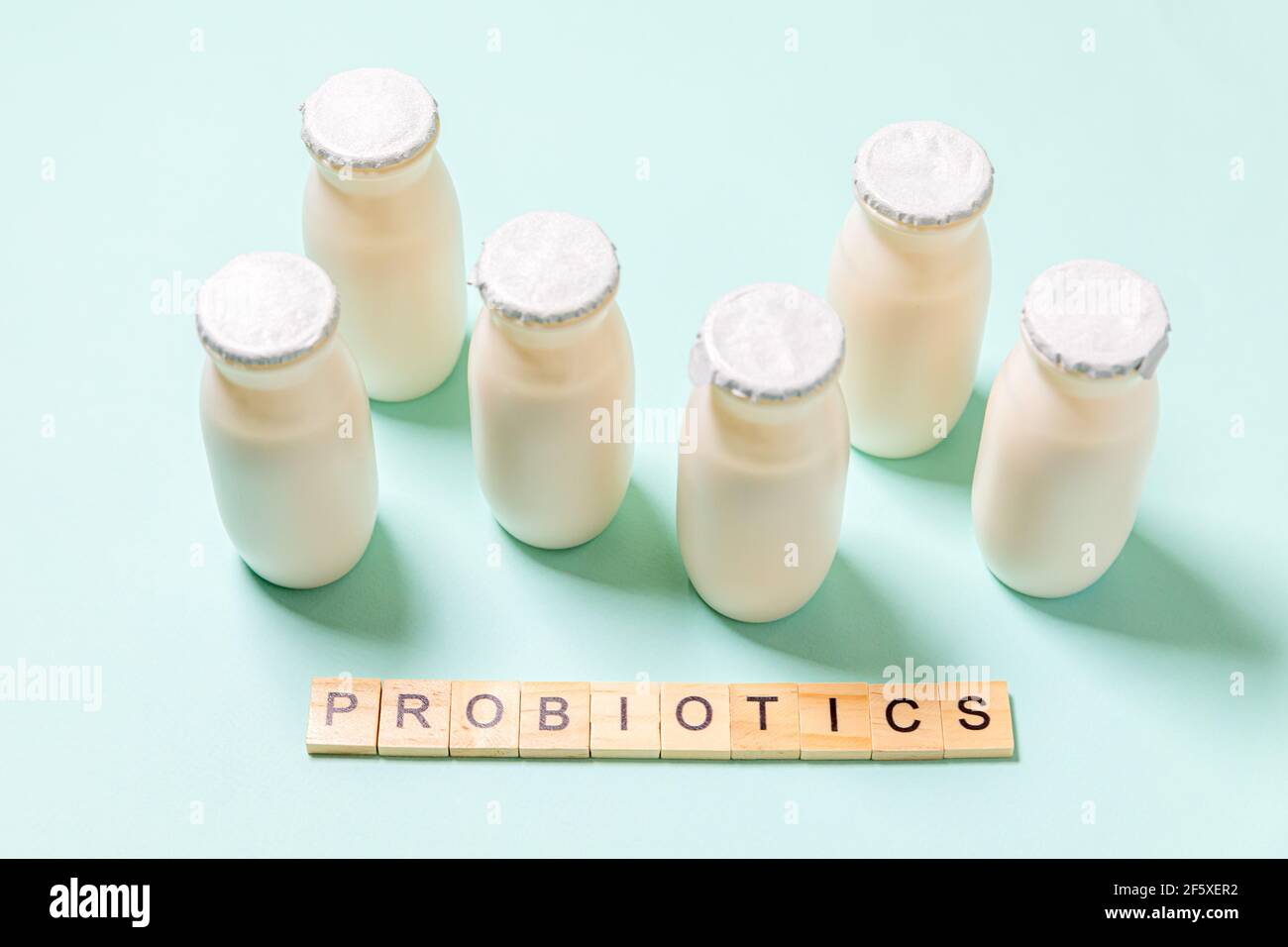 Small bottles with probiotics and prebiotics dairy drink on blue ...