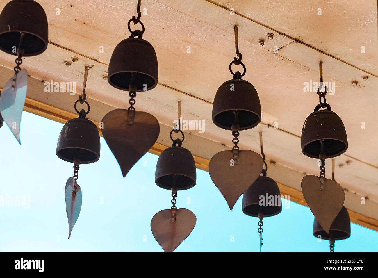 A low angle of praying bells in Buddhist temple hanging on a ceiling ...