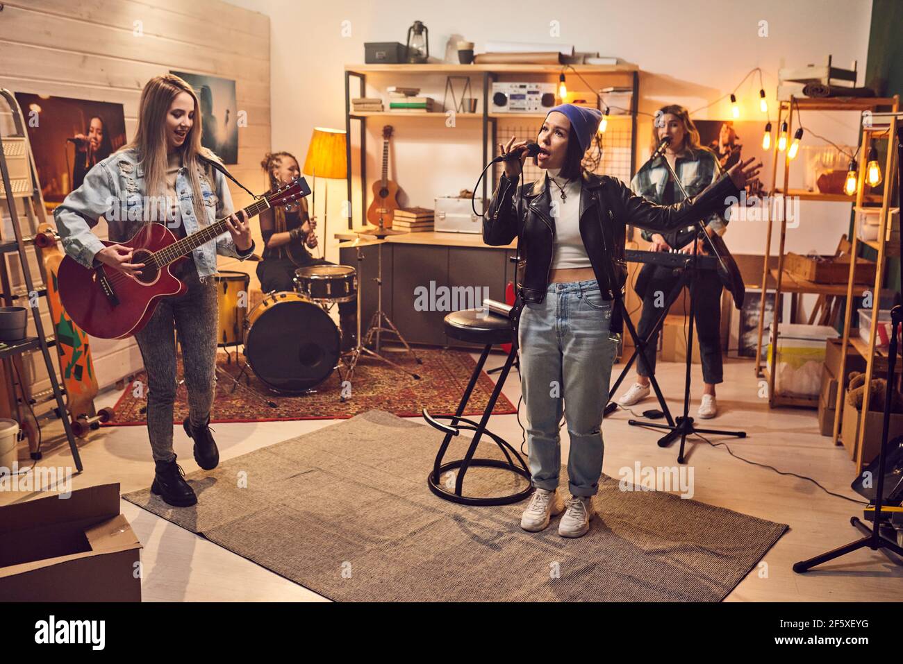 Young singer singing in microphone with other musicians who playing ...