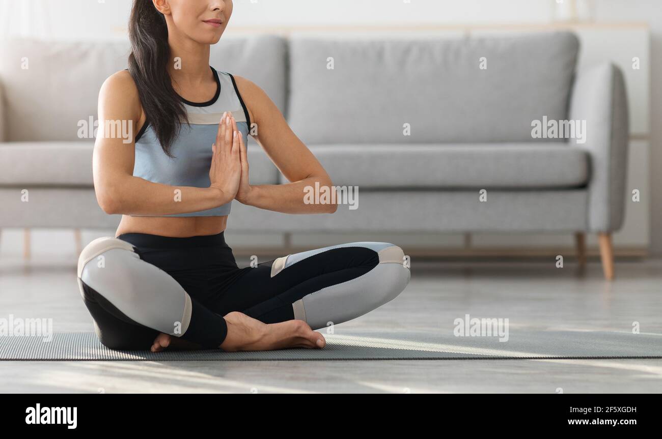 Yoga lady meditating in lotus pose at home, cropped Stock Photo - Alamy