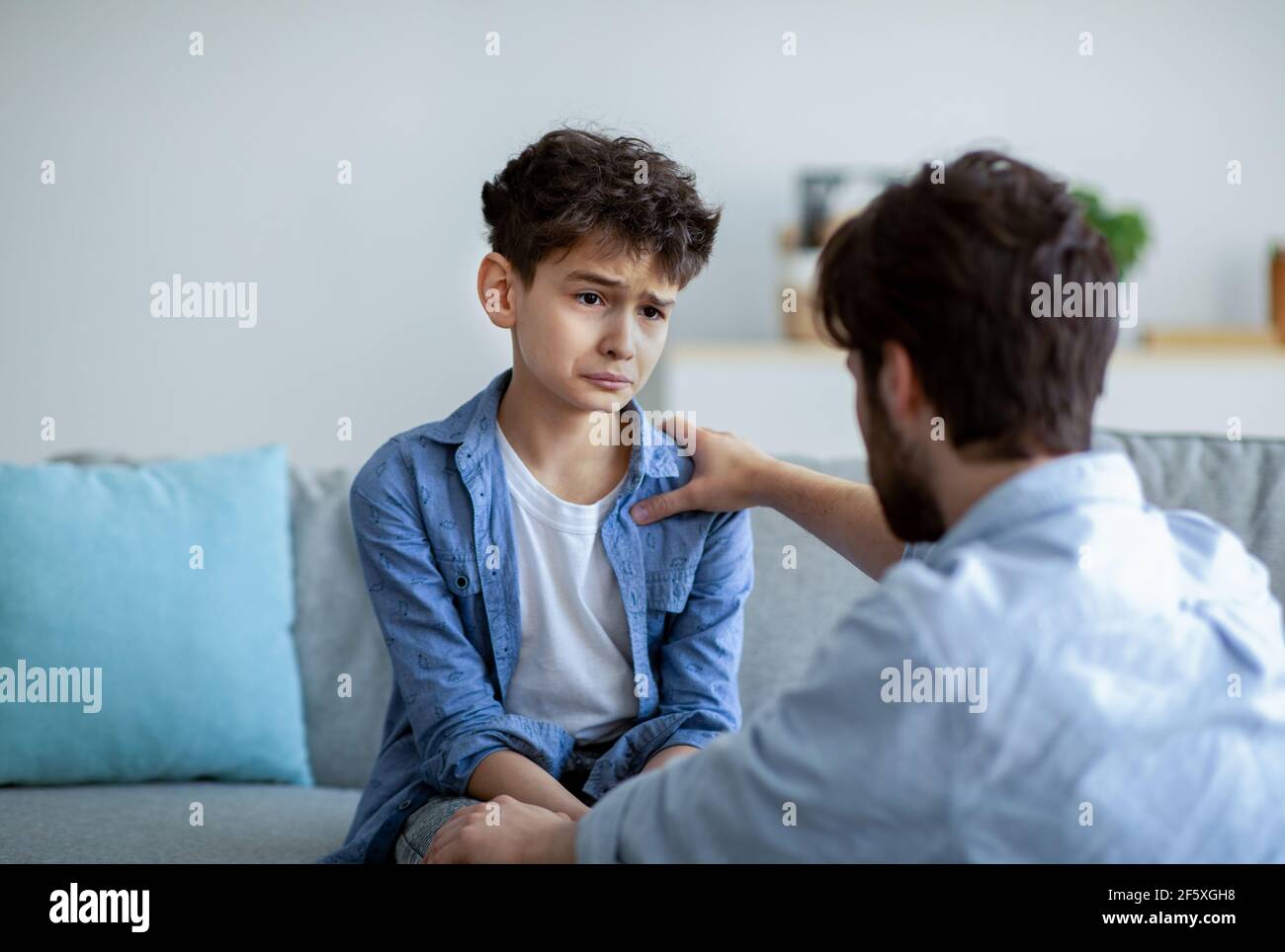 Father and sad son having heart to heart talk at home, daddy trying to ...