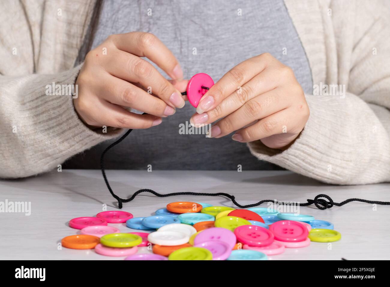 Hands impregnating a button Stock Photo - Alamy