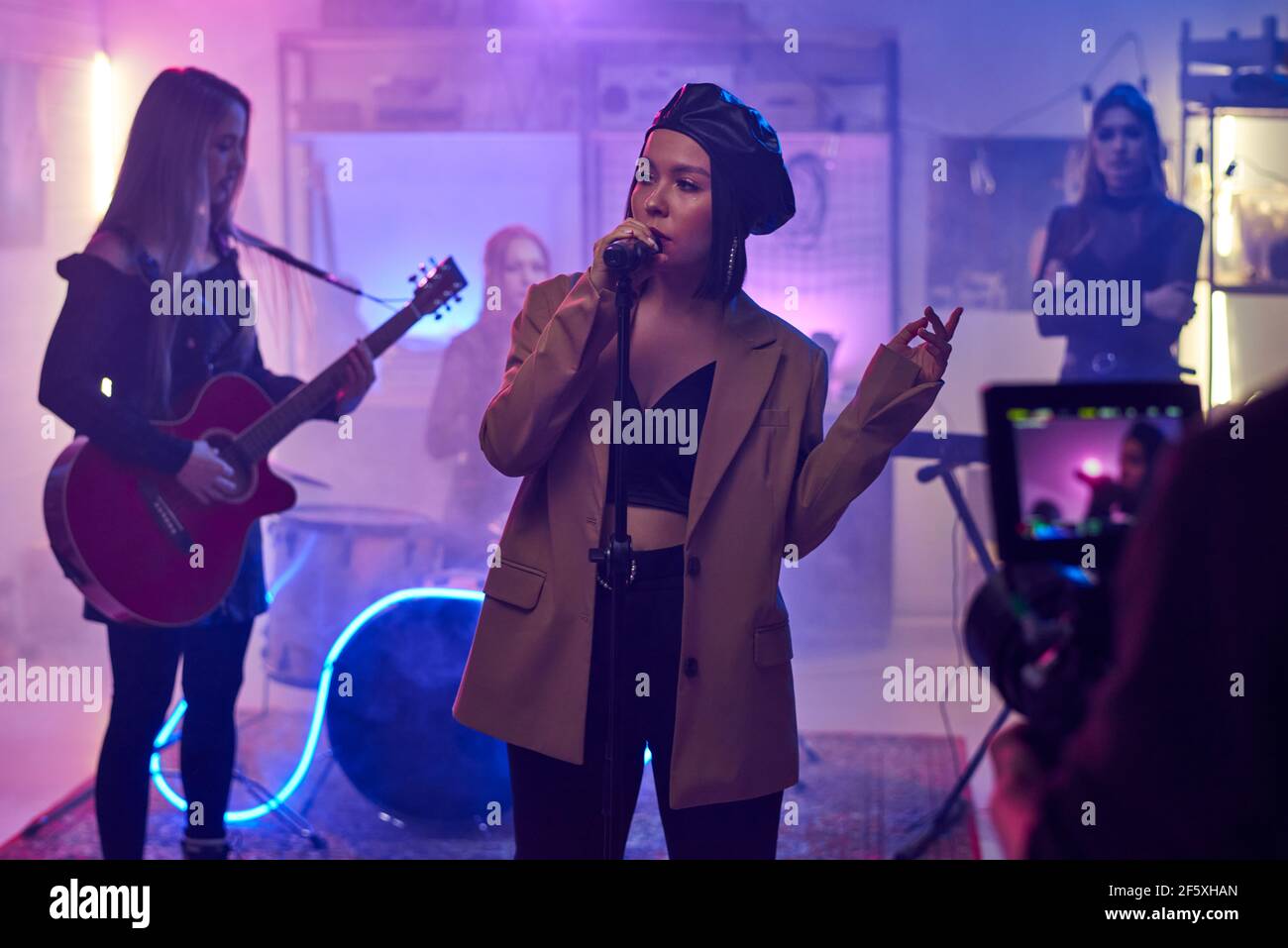 Female singer singing in microphone and performing together with her ...