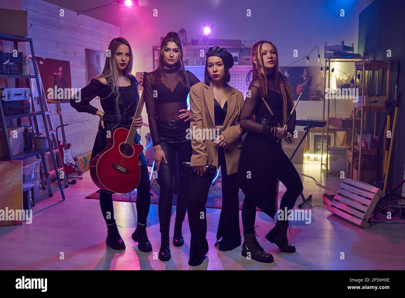 Portrait of modern female musical band looking at camera during their ...