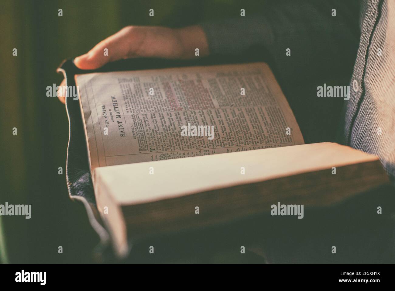 Man reading the gospel in low light Stock Photo - Alamy