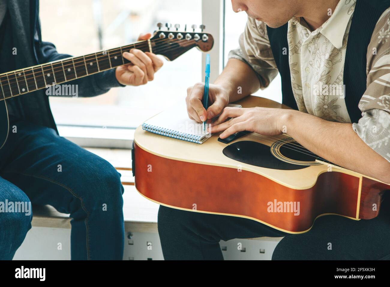 Learning to play the guitar. The teacher explains to the student the ...