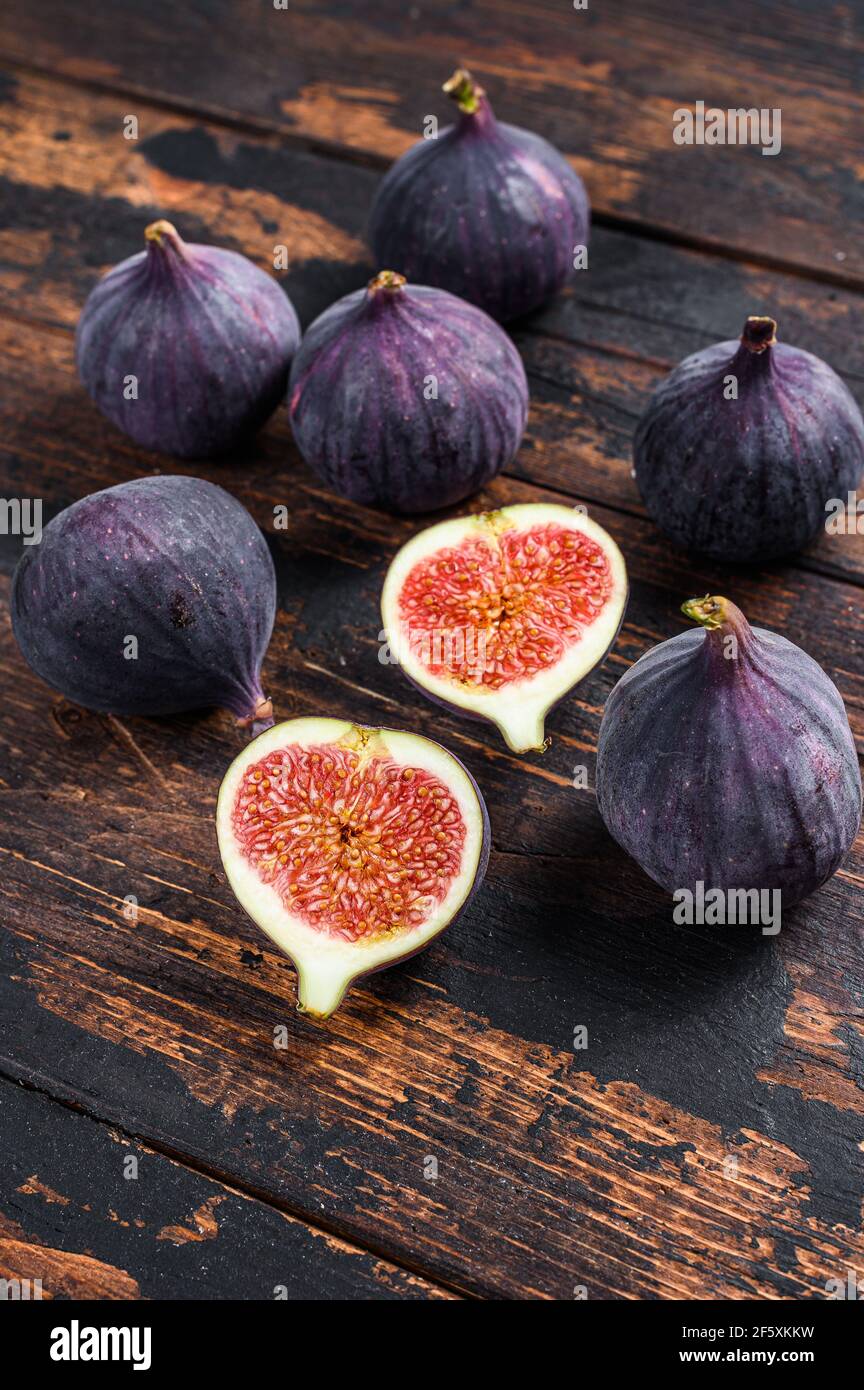 Purple figs on a wooden table. Dark wooden background. Top view Stock ...