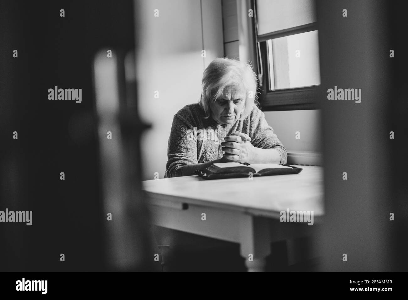 Old woman spending time alone with god, praying and reading bible Stock ...