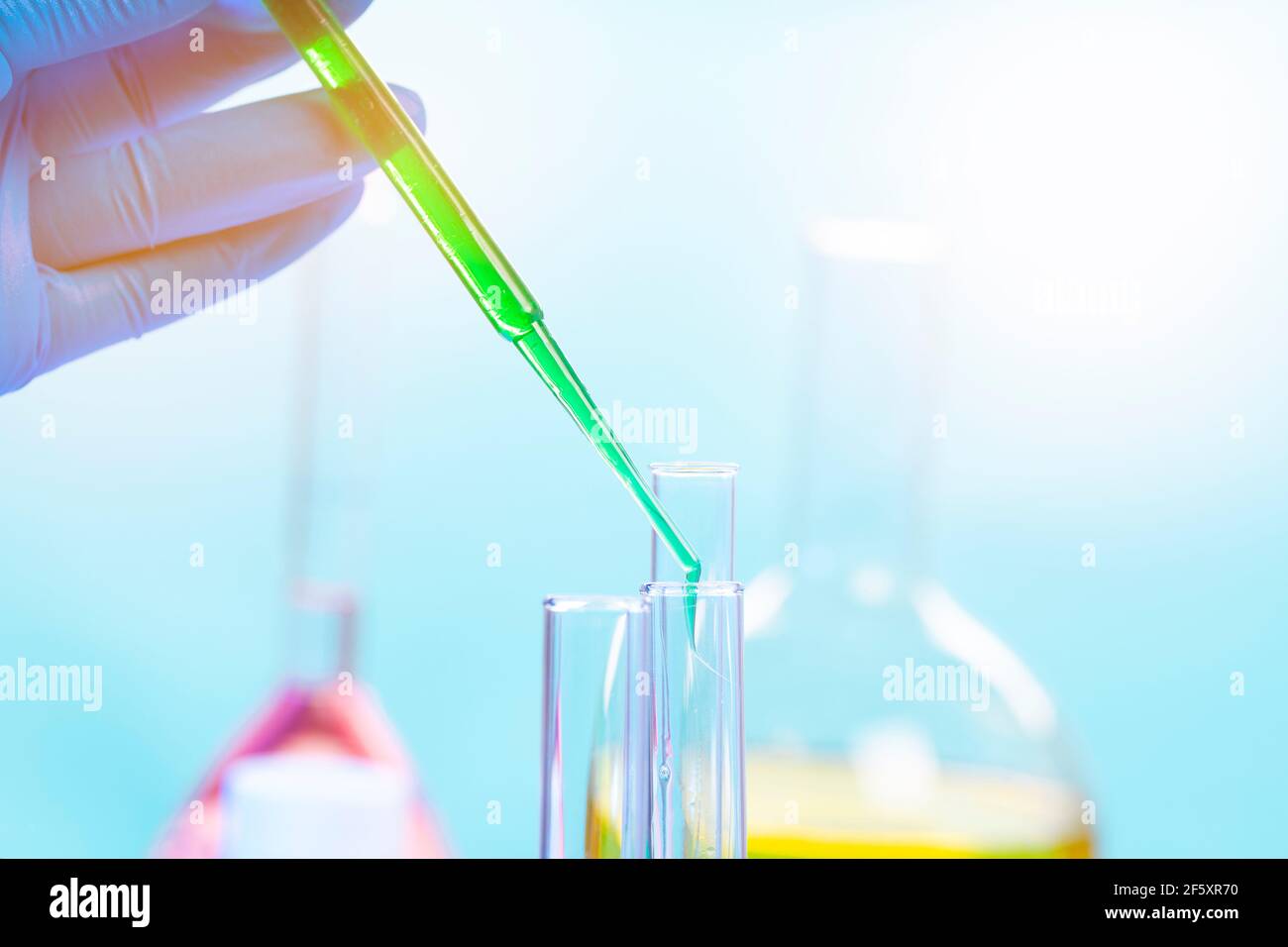 Chemical test tubes and pipette with green liquid close up in a ...