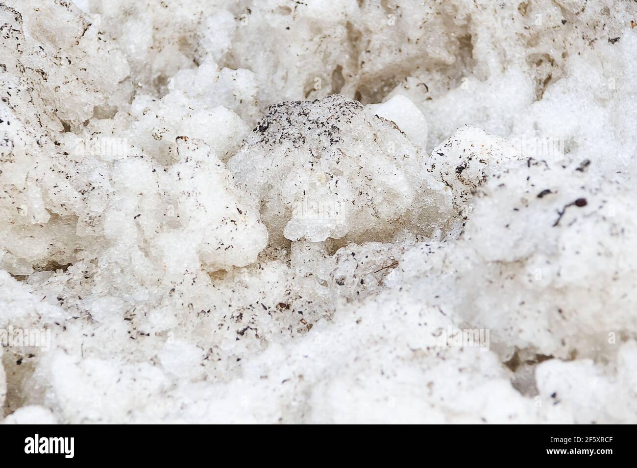 Early spring time dirty gray melted snow with sand pattern texture ...
