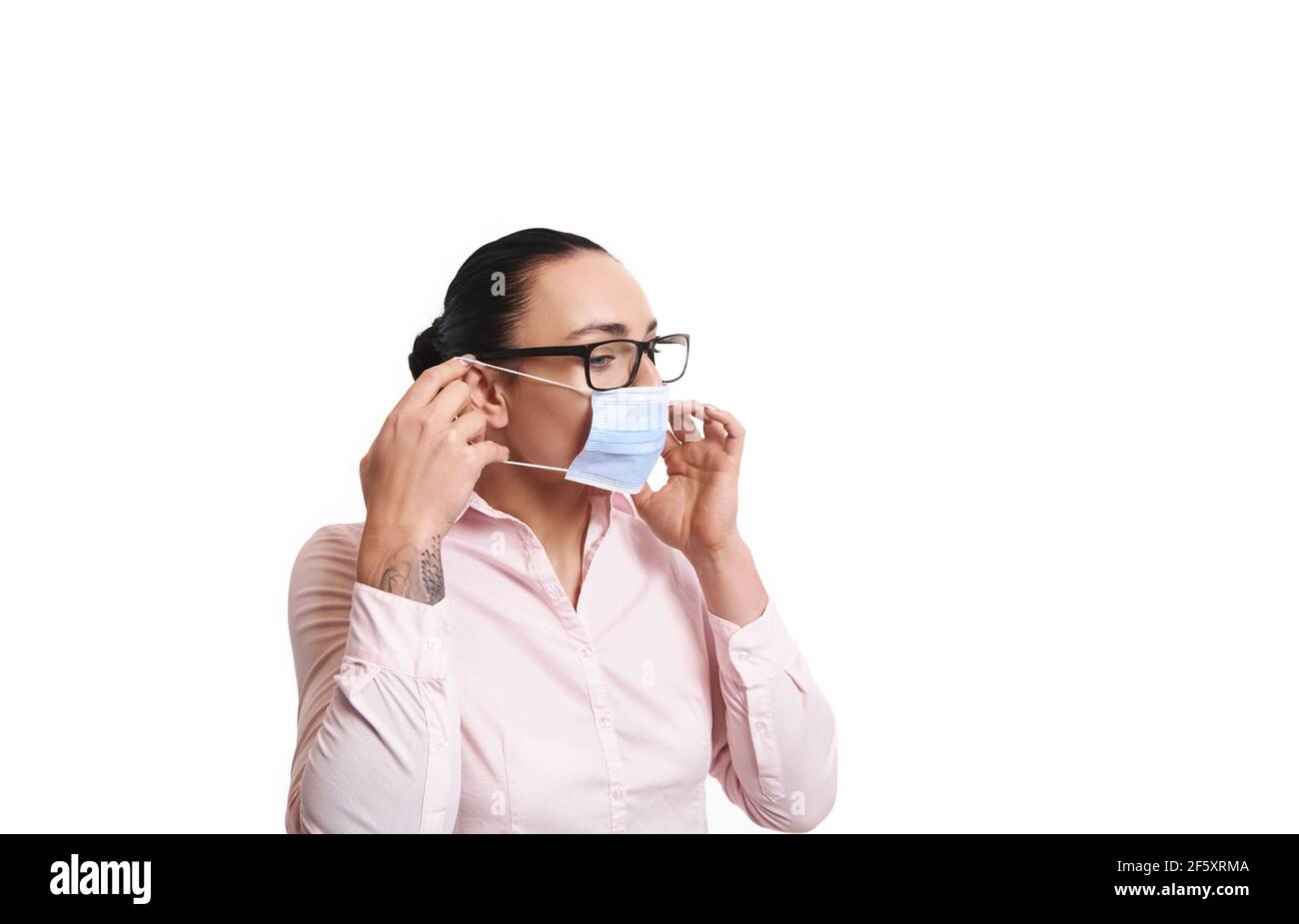 Side view of a young business woman putting on a medical protective ...