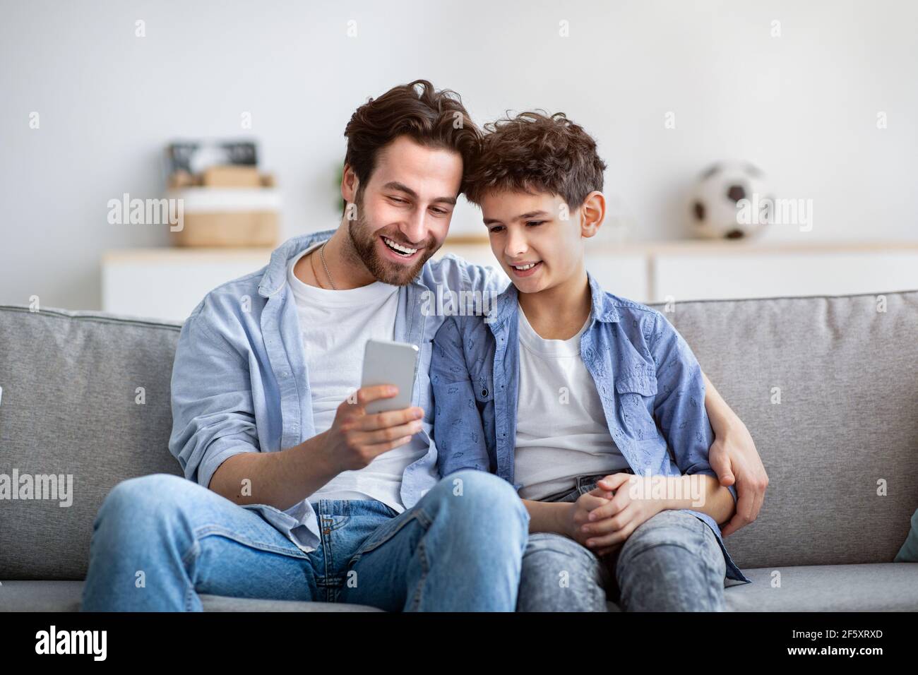 Family gadgets concept. Happy father showing new app to his son ...