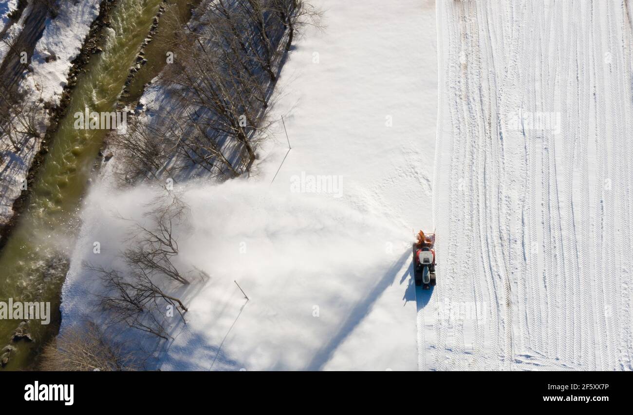 Snow thrower is cleaning the football field from the snow. Aerial shot ...