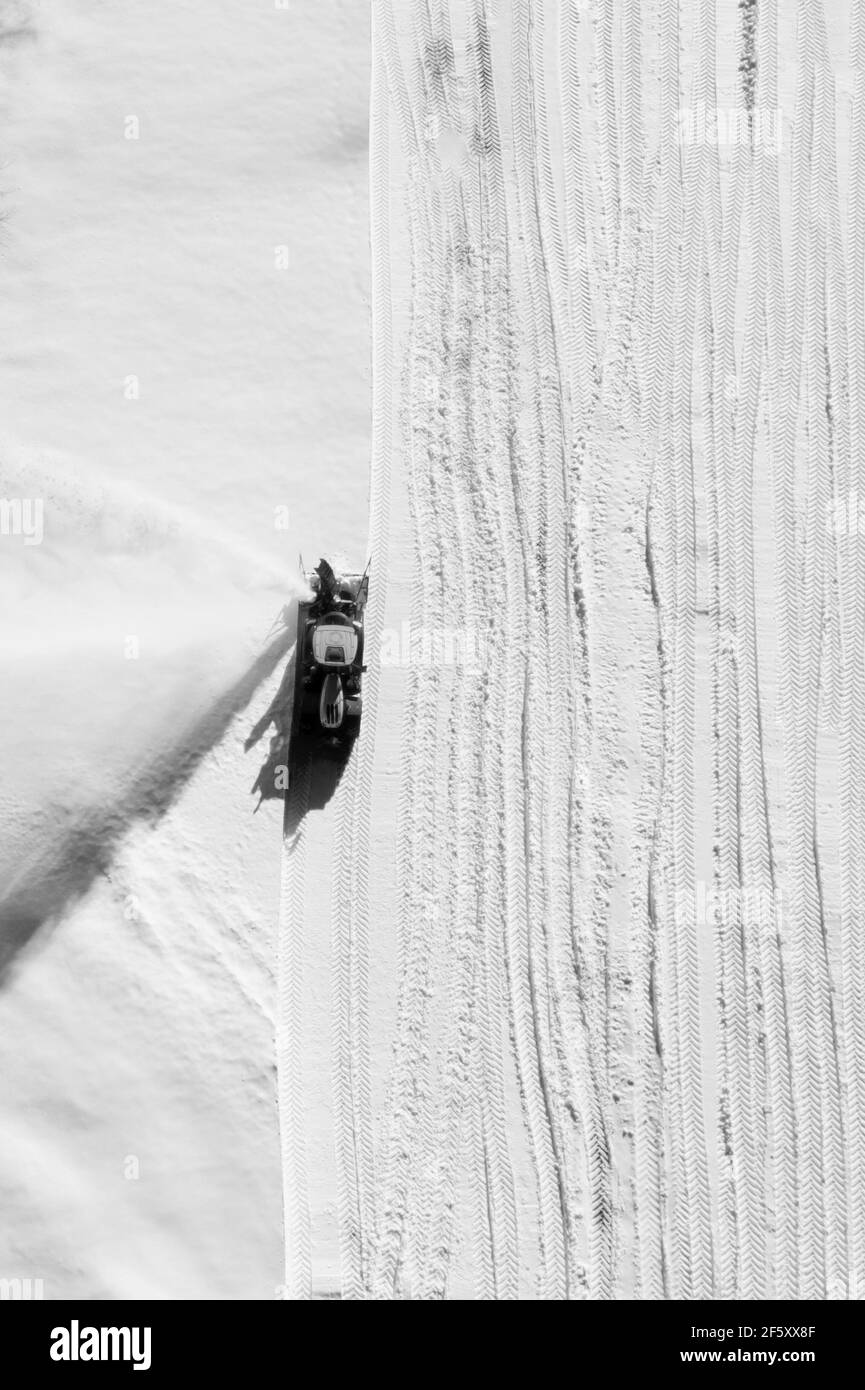 Snow thrower is cleaning the snow. Bird’s eye view. Black and white ...