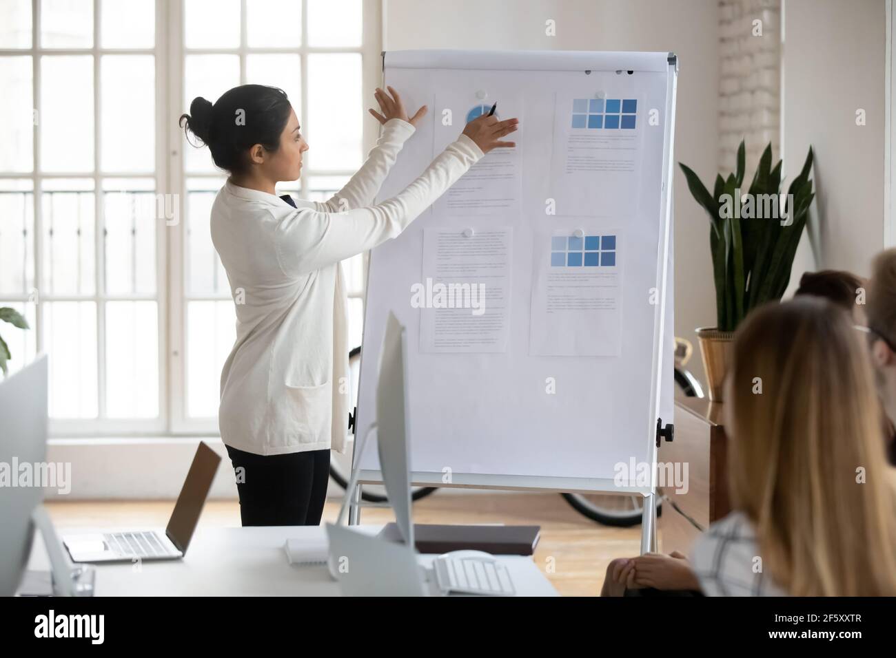 Indian female coach make flip chart presentation Stock Photo - Alamy