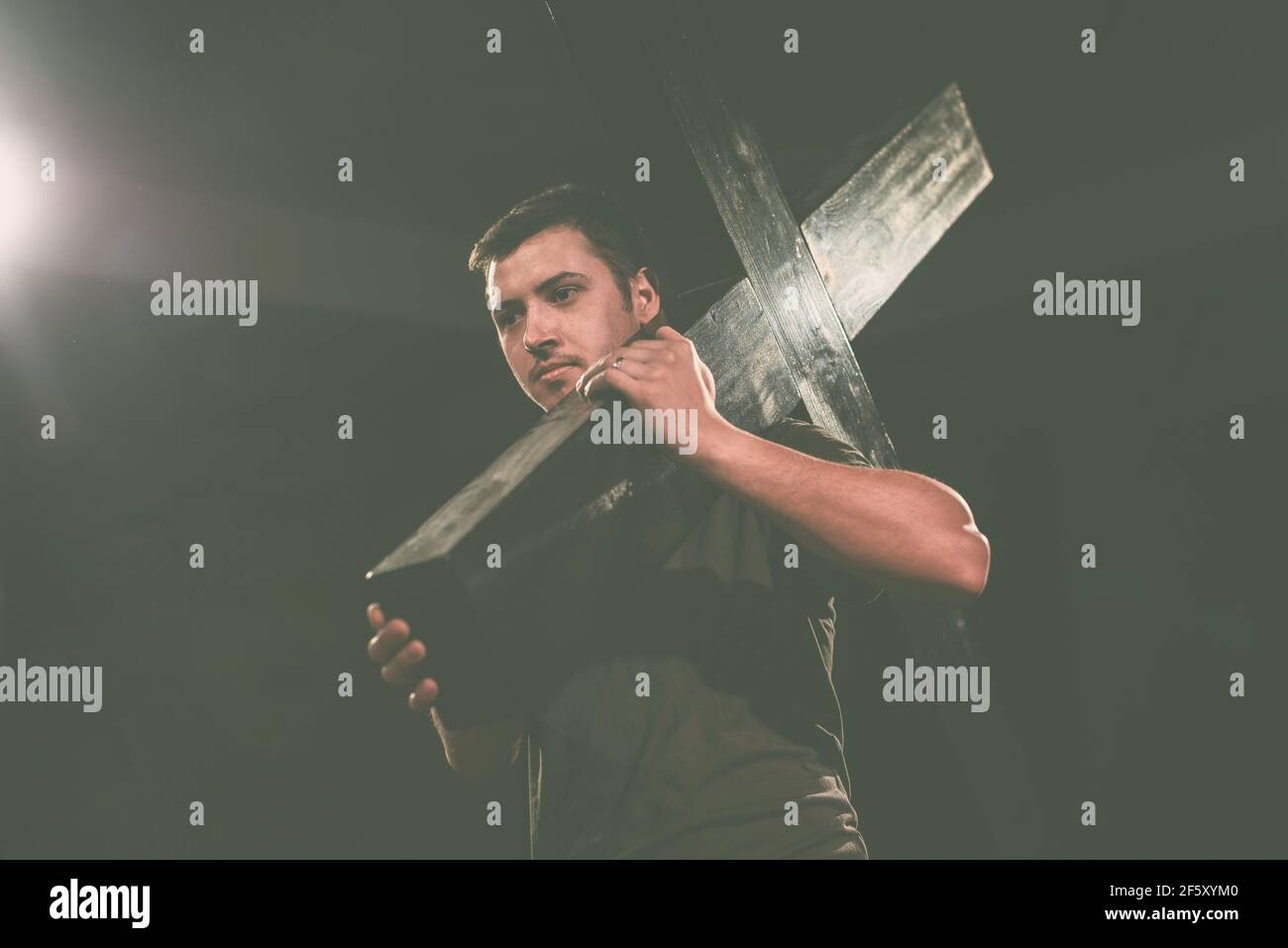 Young man carrying a wooden cross Stock Photo - Alamy