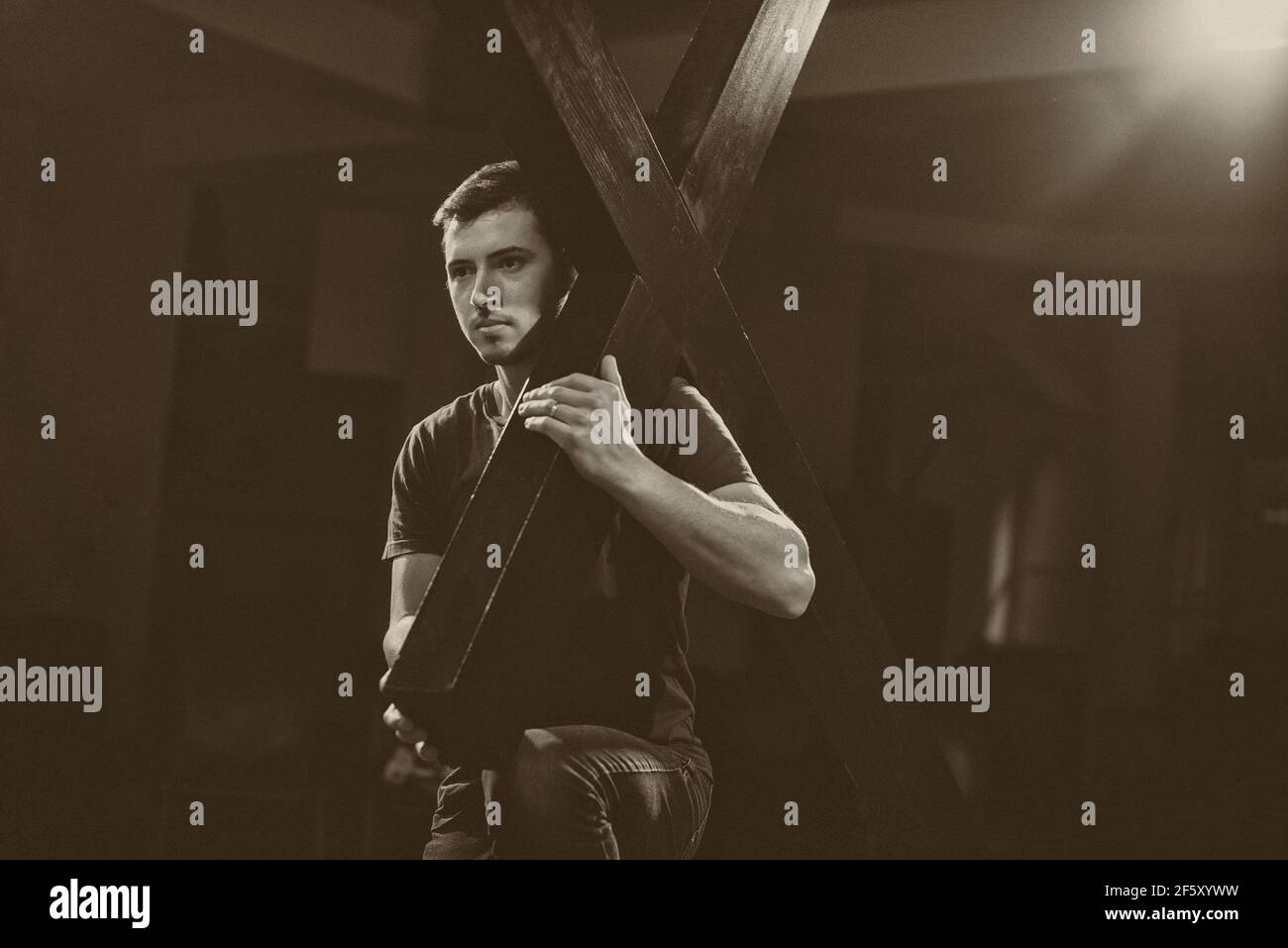 Young man carrying a wooden cross Stock Photo - Alamy