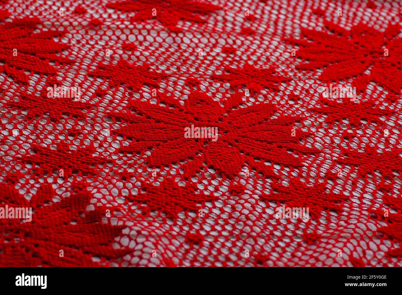 knitted lace flounces, red. material is folded randomly on horizontal ...
