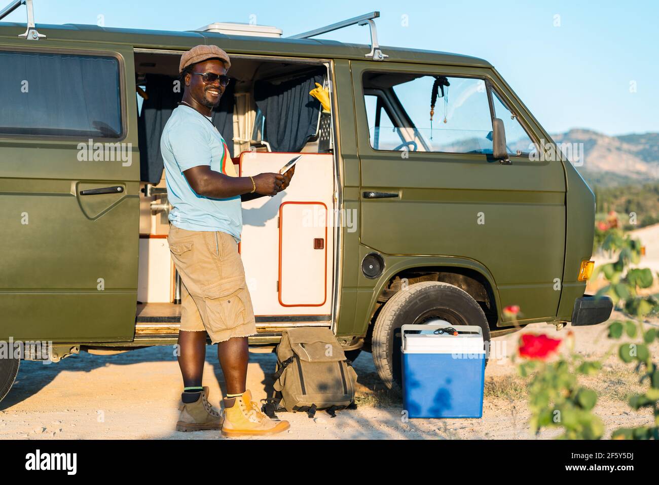black man with glasses, and mobile phone in camper van Stock Photo - Alamy