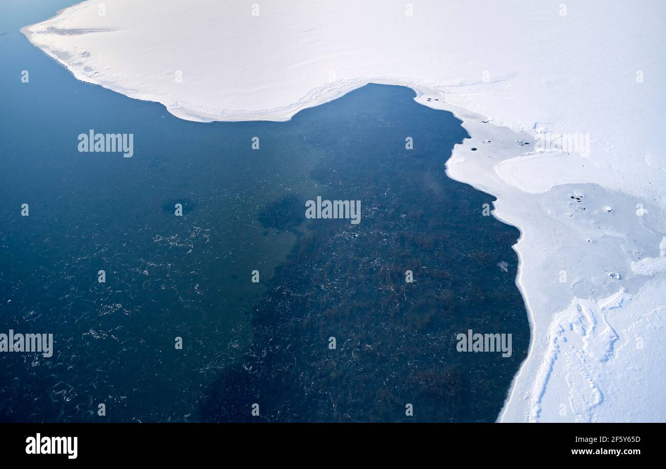 Cold remote shoreline in snow Stock Photo - Alamy