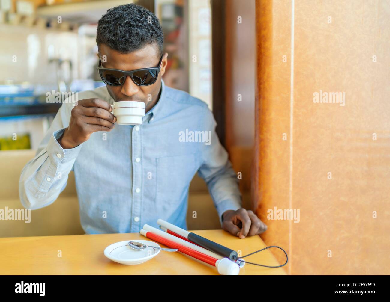 young blind african man having a coffee Stock Photo - Alamy