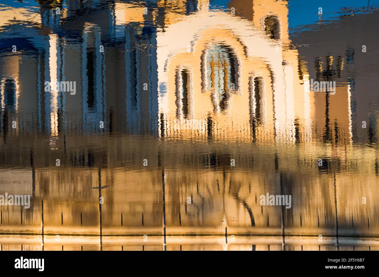 Color reflection of an architectural building in water with ripples ...
