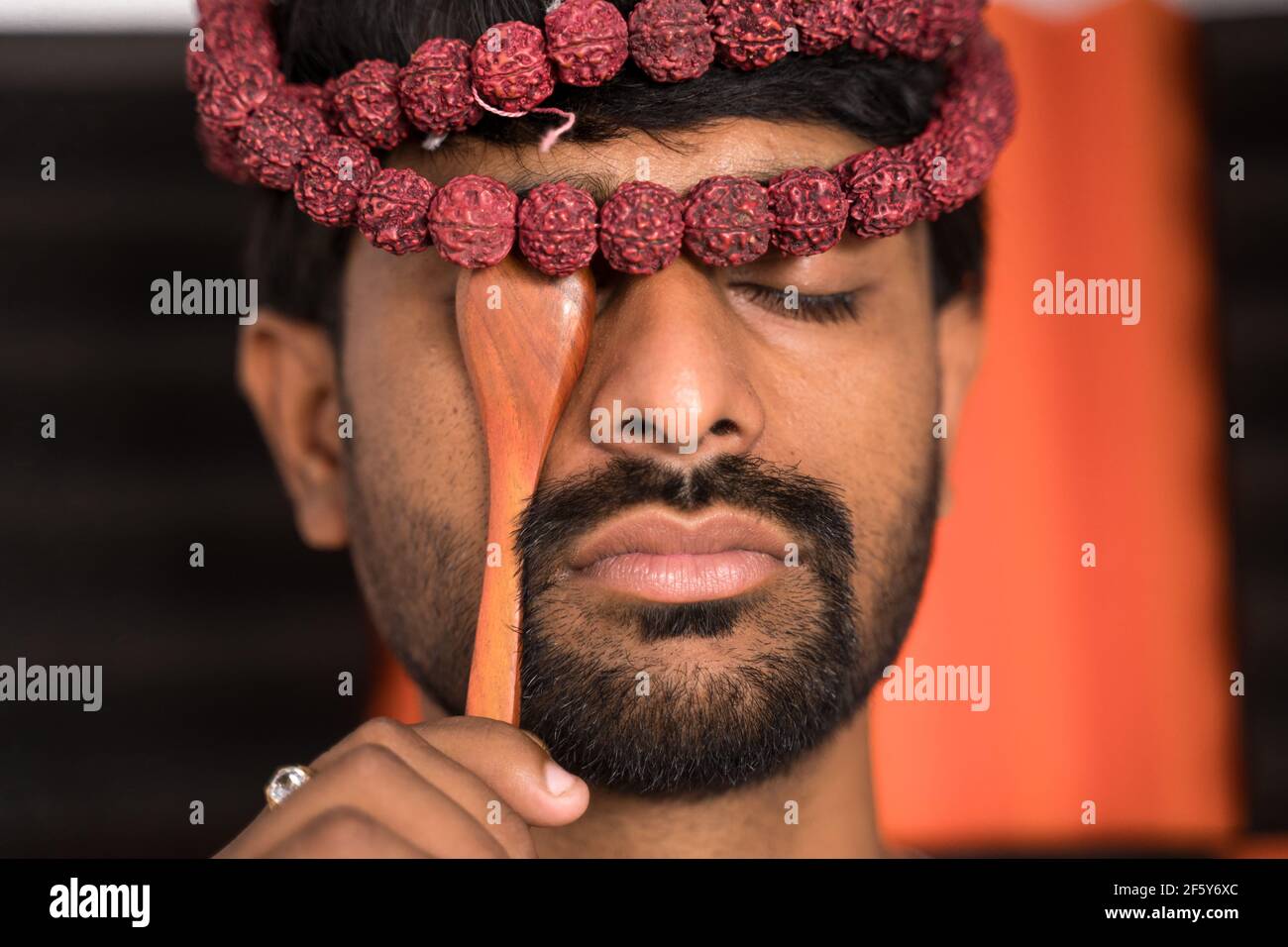 A portrait of an Indian male covering his eyes with a Shambhala ...