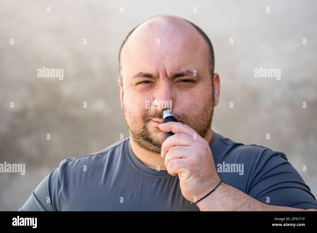 A closeup portrait of a Romanian male shaving or trimming his nose hair ...