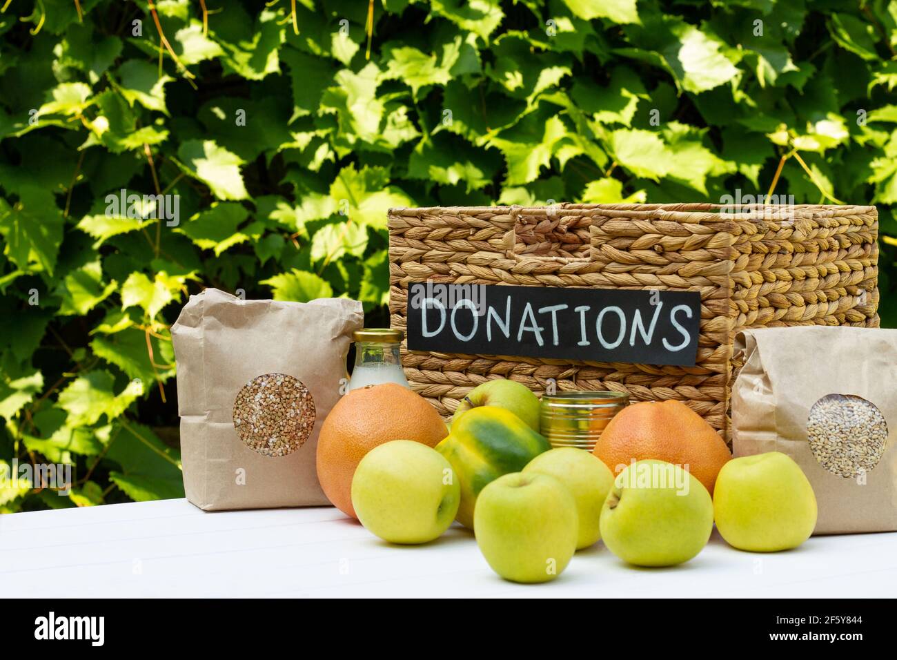 Various food in a box for donations on a table on a background of ...