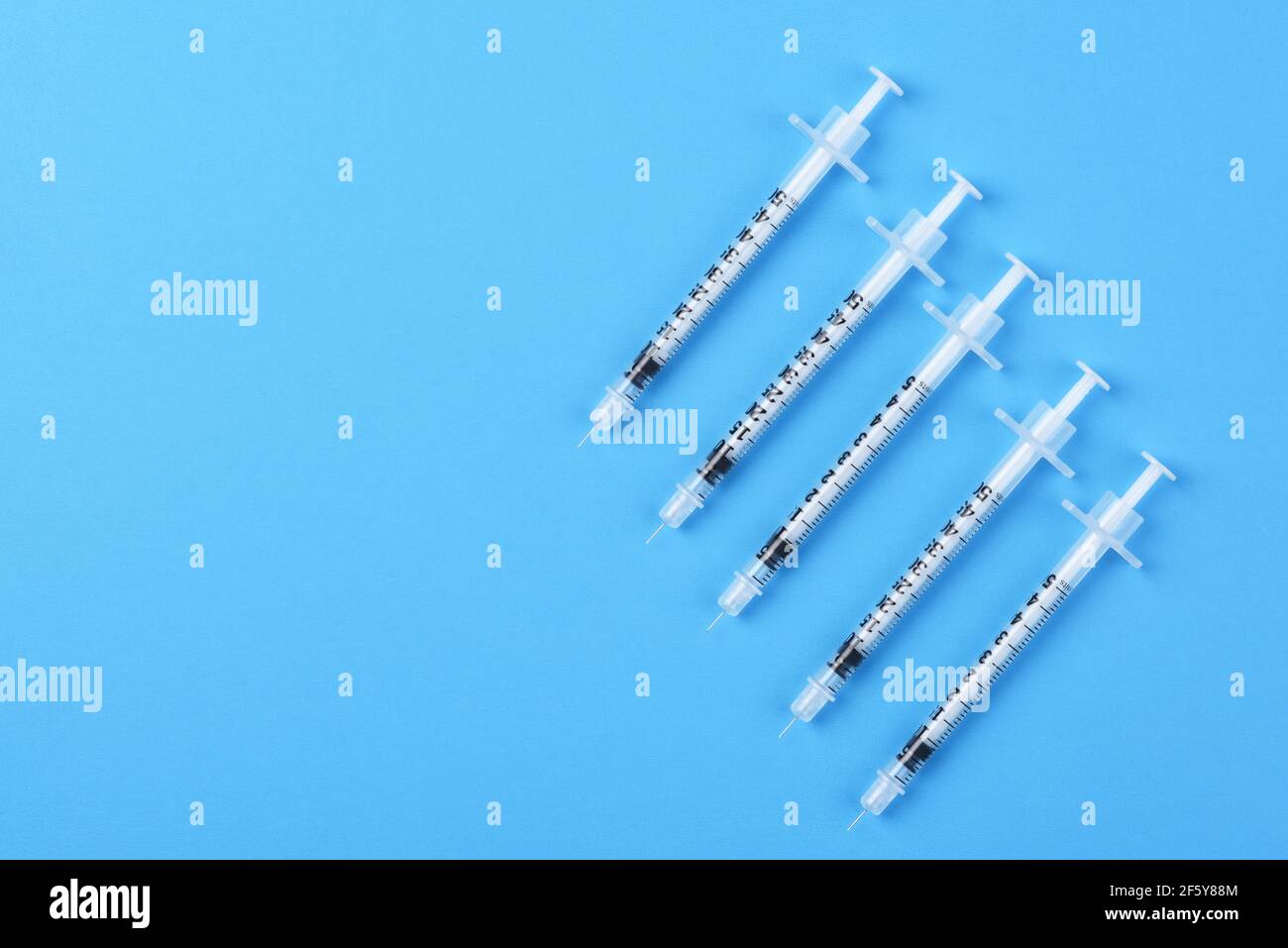 Five new syringes on a blue background with copy space Stock Photo - Alamy