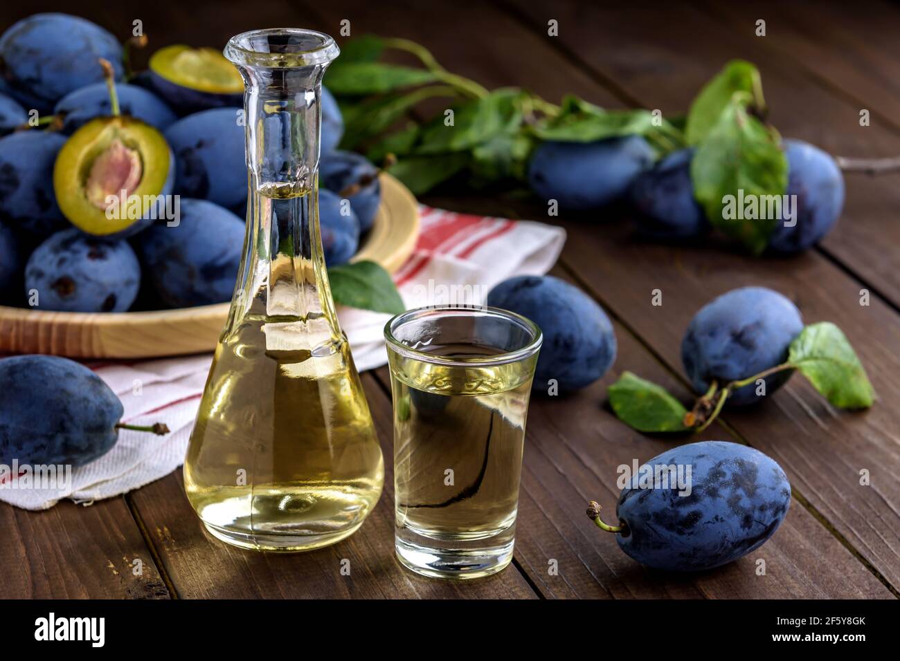 Plum brandy or schnapps in glasses and fresh tasty plums on a wooden ...