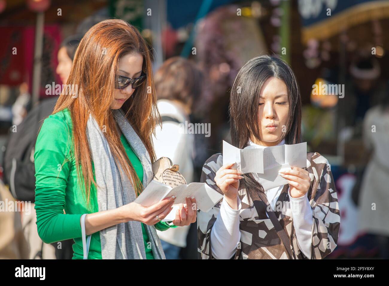 Japanese females read their omikuji - fortune telling paper that ...
