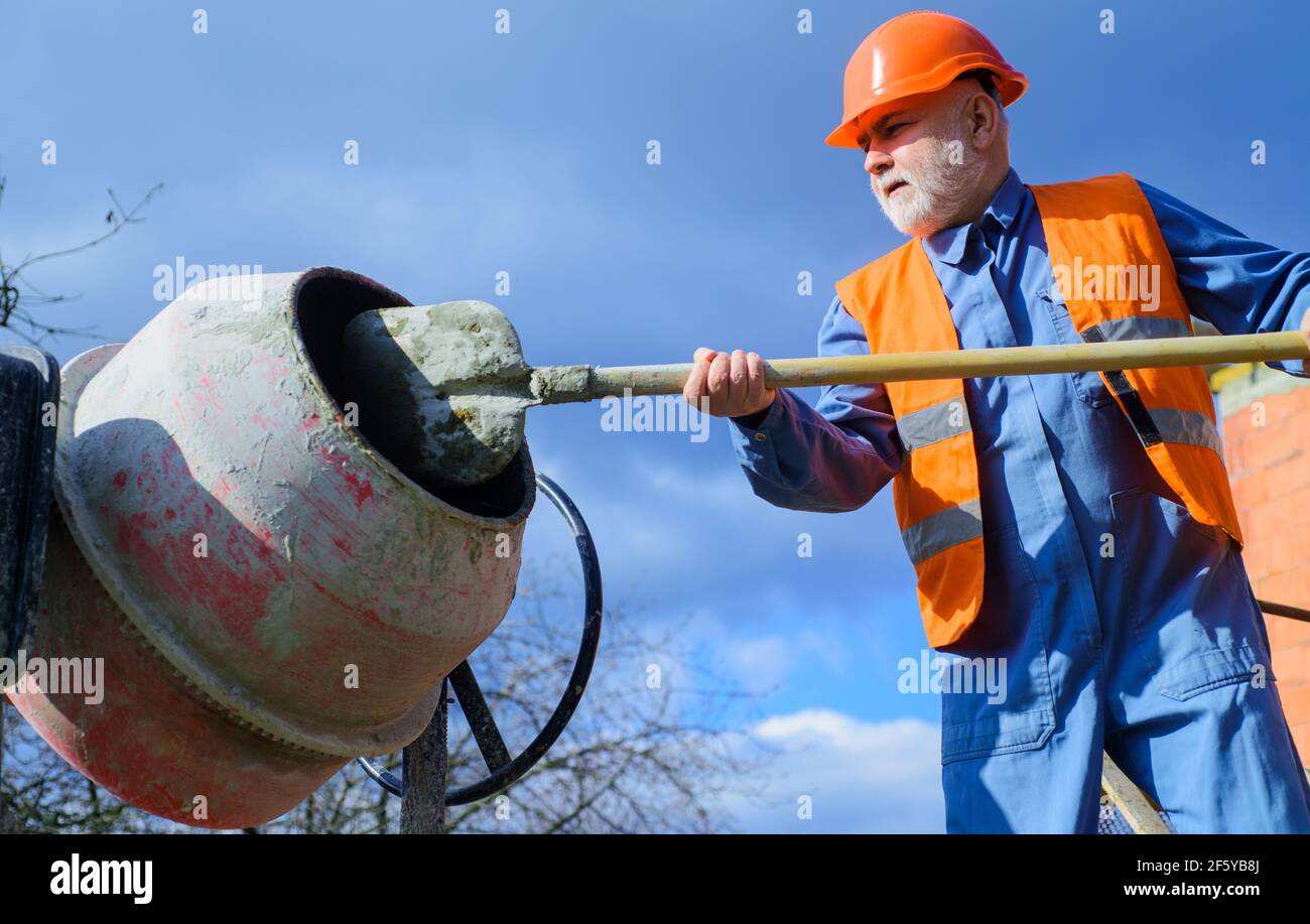 Construction worker works with concrete mixer. Cement creation. Builder ...