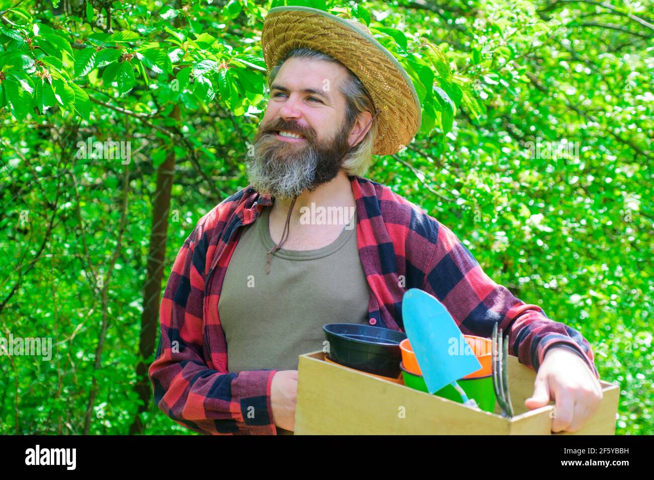 Springtime. Happy farmer in spring garden. Gardener with gardening ...