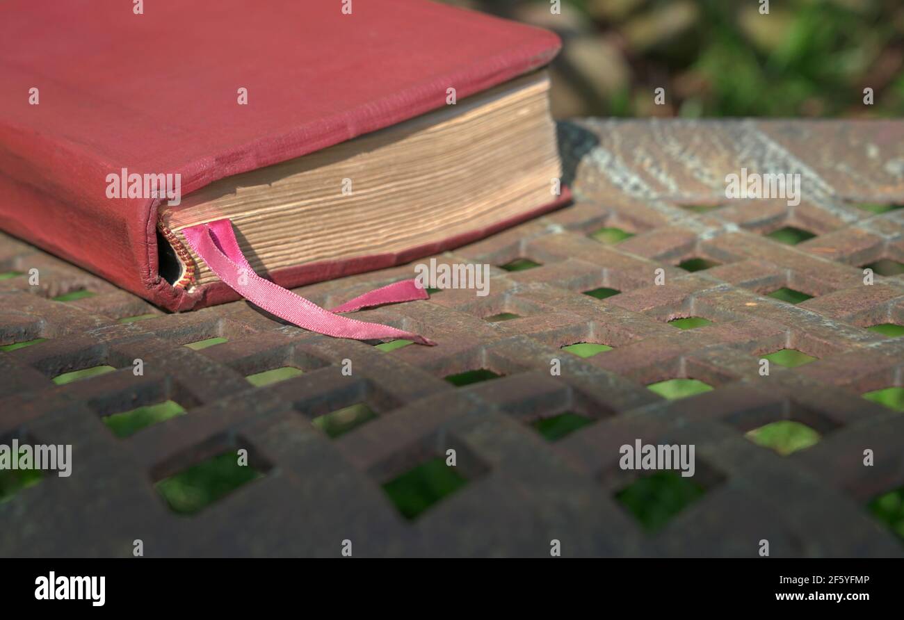 Red brown leather cover book with bookmark ribbon on a steel bench ...