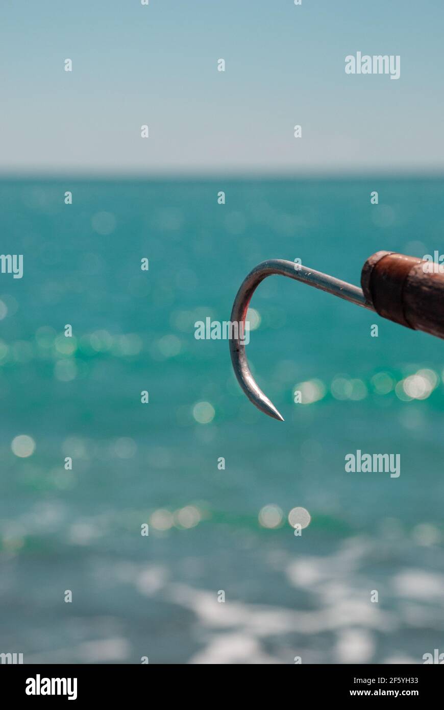 Metallic hook ready to fish in the middle of the sea late in the ...